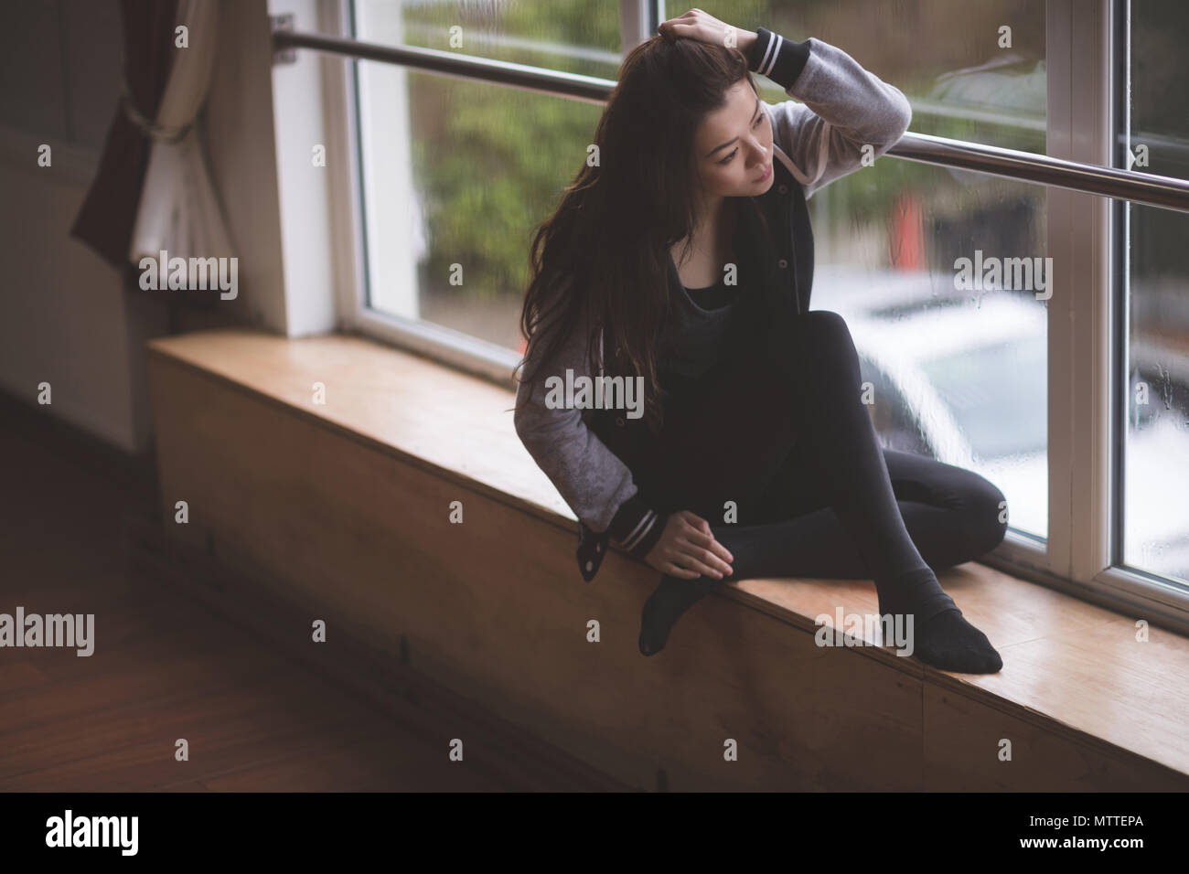 Female dancer looking through window in dance studio Stock Photo - Alamy