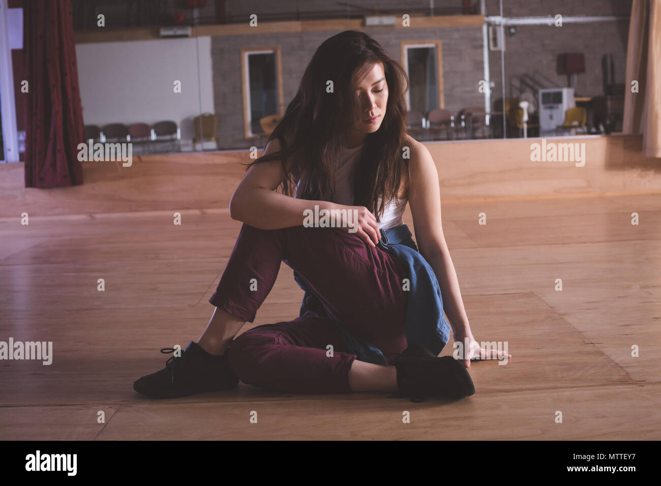 Female dancer relaxing in dance studio Stock Photo - Alamy