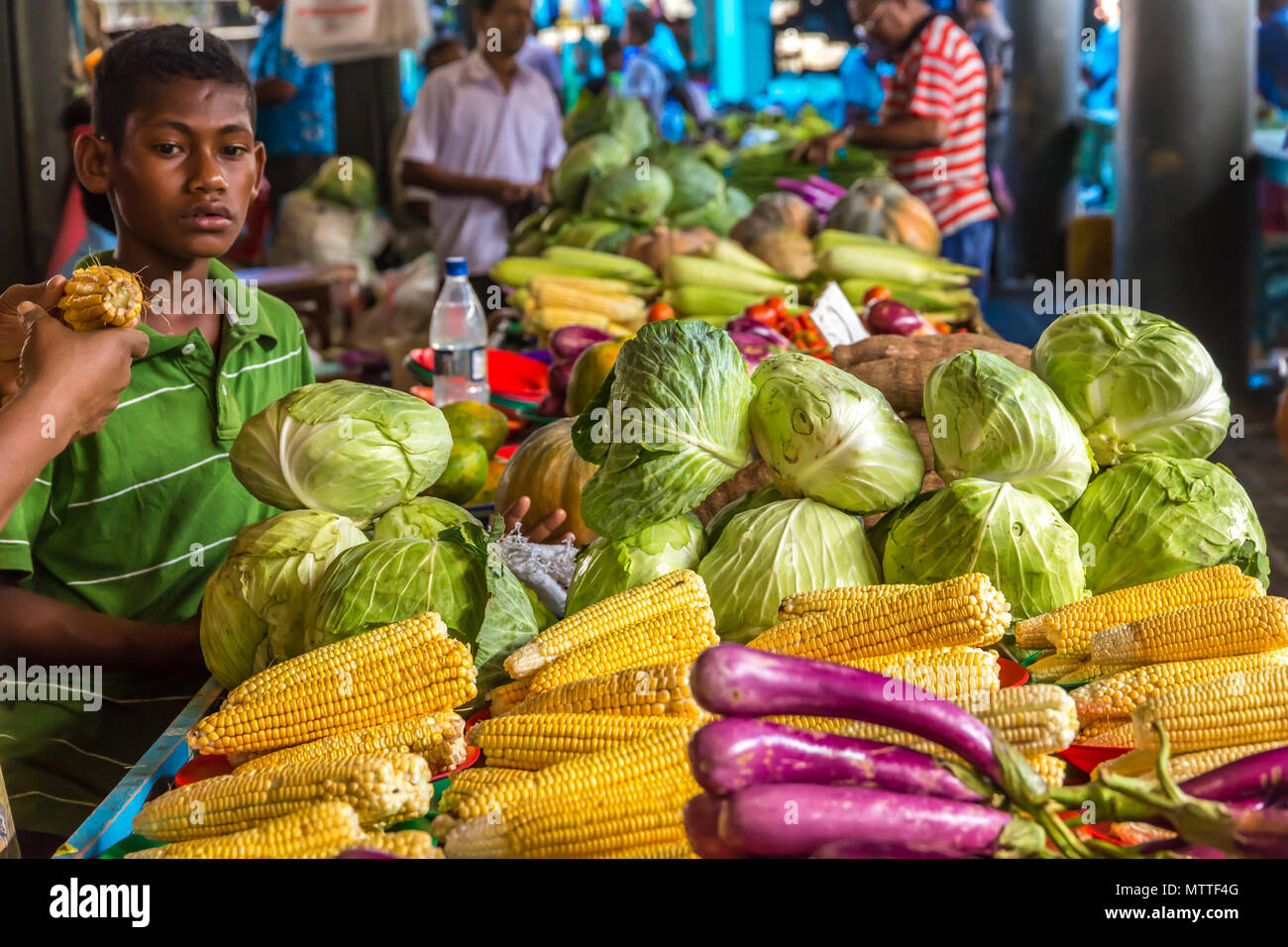 Merchant and vegetables and fruit for sale at a local Fijian vegetable ...