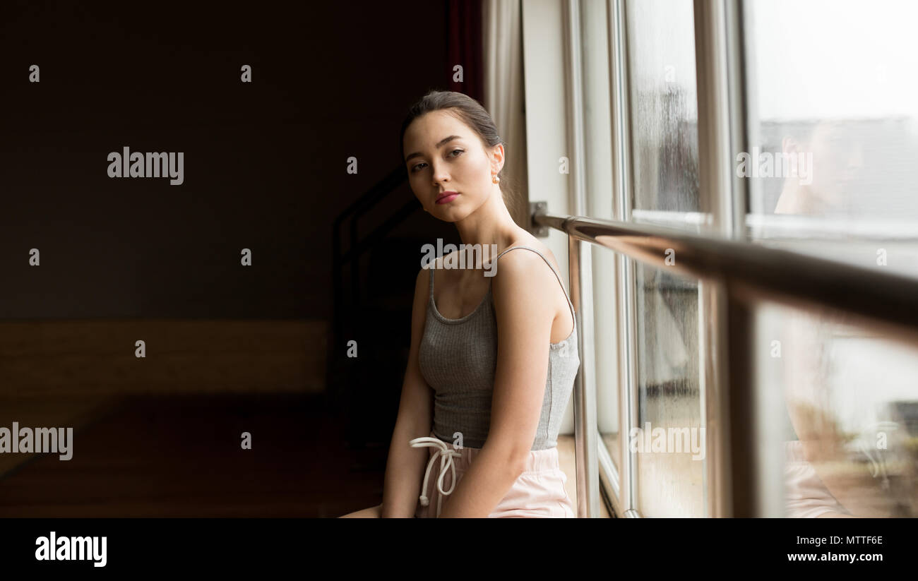 Female dancer looking through window in dance studio Stock Photo - Alamy