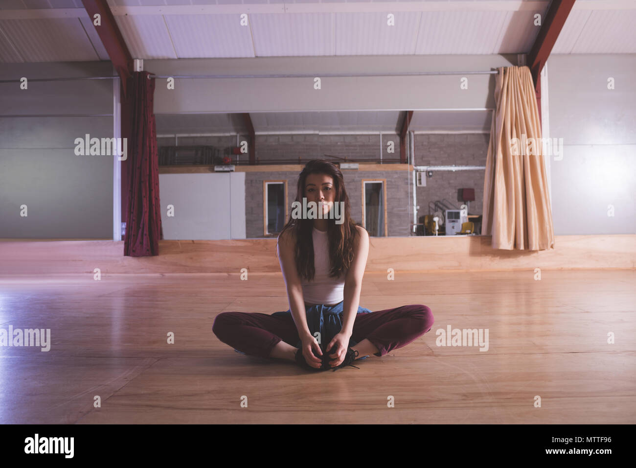 Female dancer relaxing in dance studio Stock Photo - Alamy