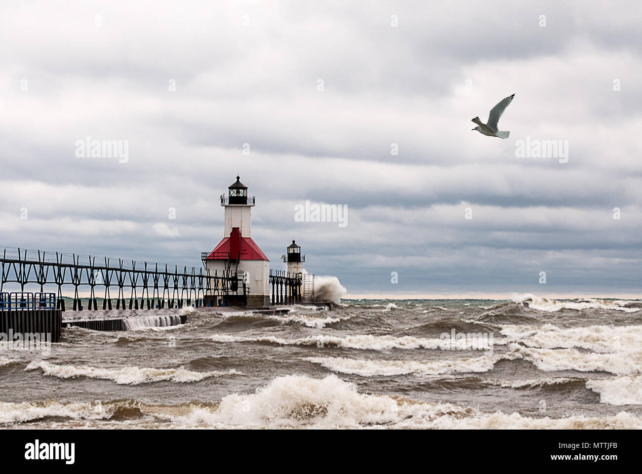 A small lighthouse out on a pier in St. Joeseph Michigan during stormy ...