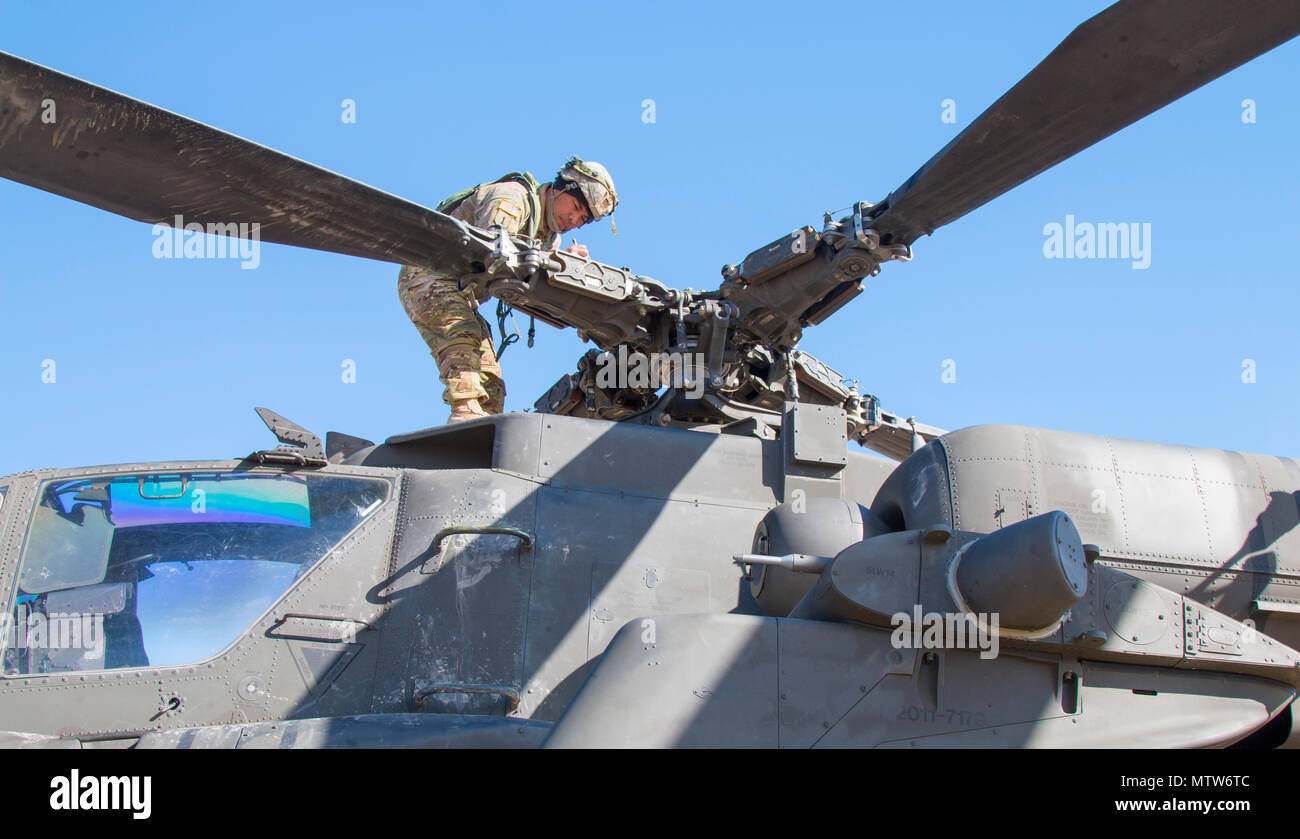 A technical inspector conducts a thorough check of an AH-64 Apache ...