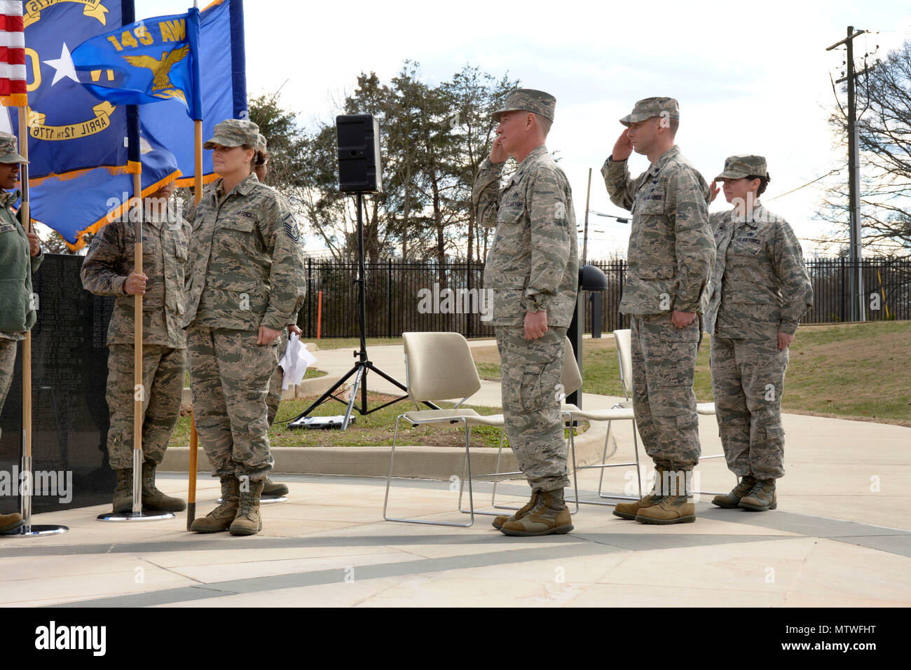 U.S. Air Force members render salutes as the National Anthem plays ...