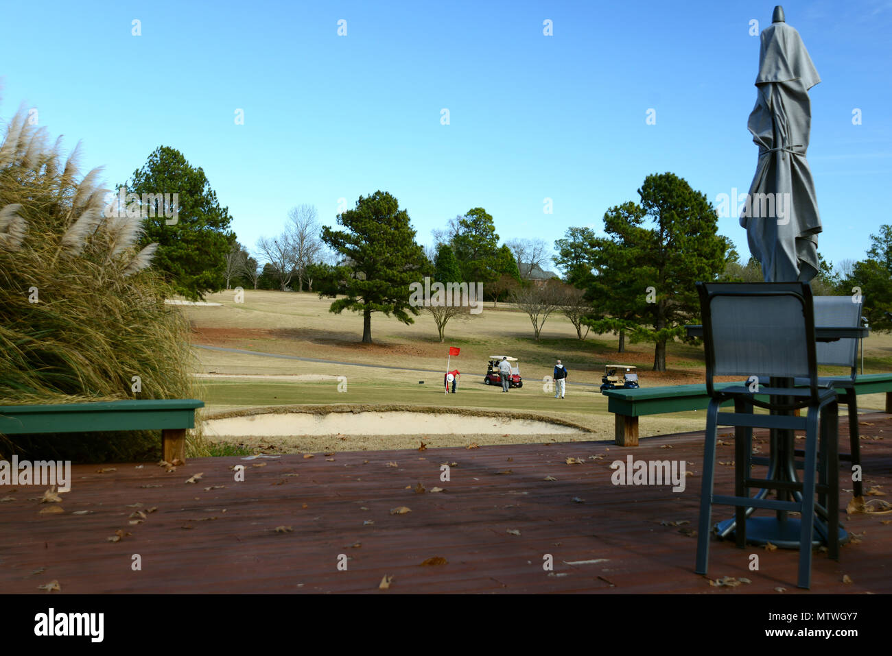 Team Shaw members play golf at the 18th hole near the patio at the ...