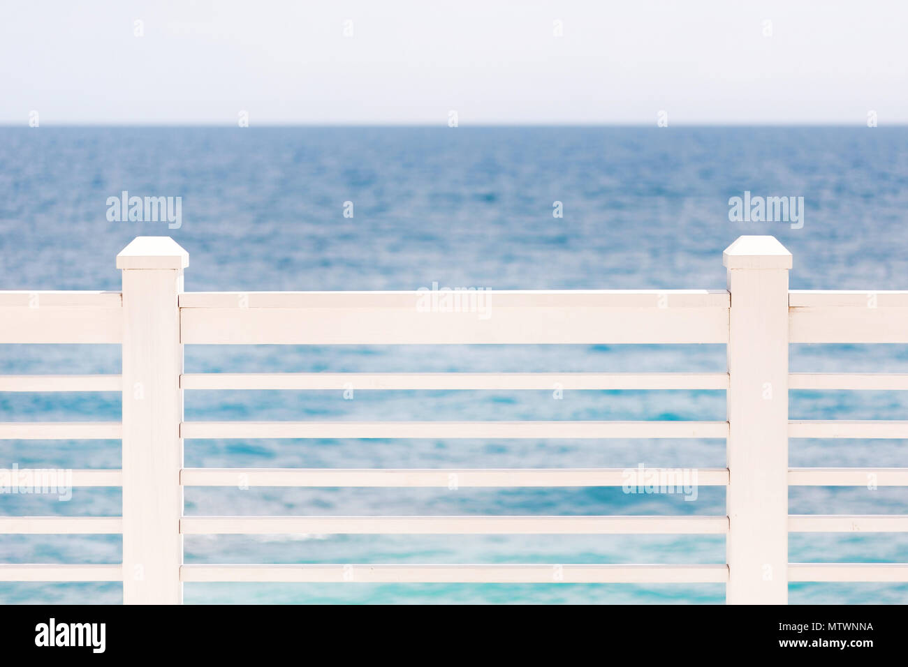 Terrace or balcony with wooden white fence, sea or ocean and clear sky ...