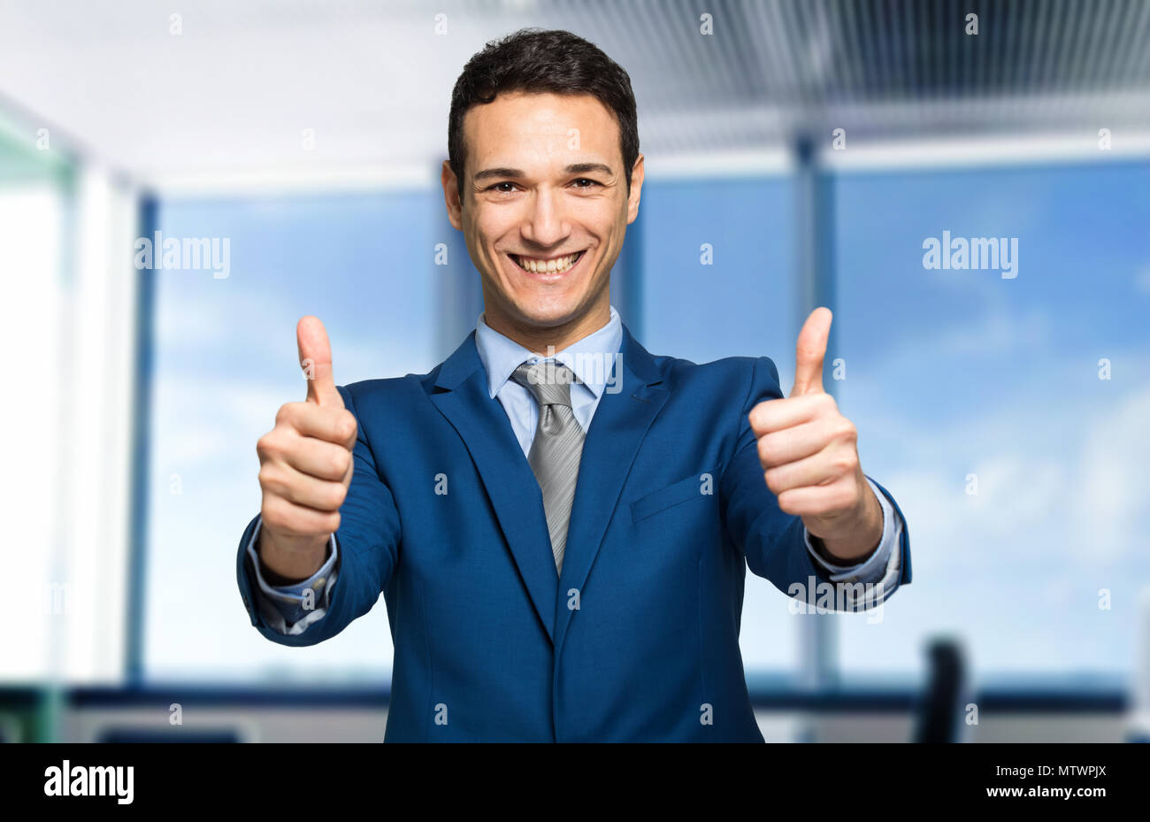 Businessman giving two thumbs up Stock Photo - Alamy