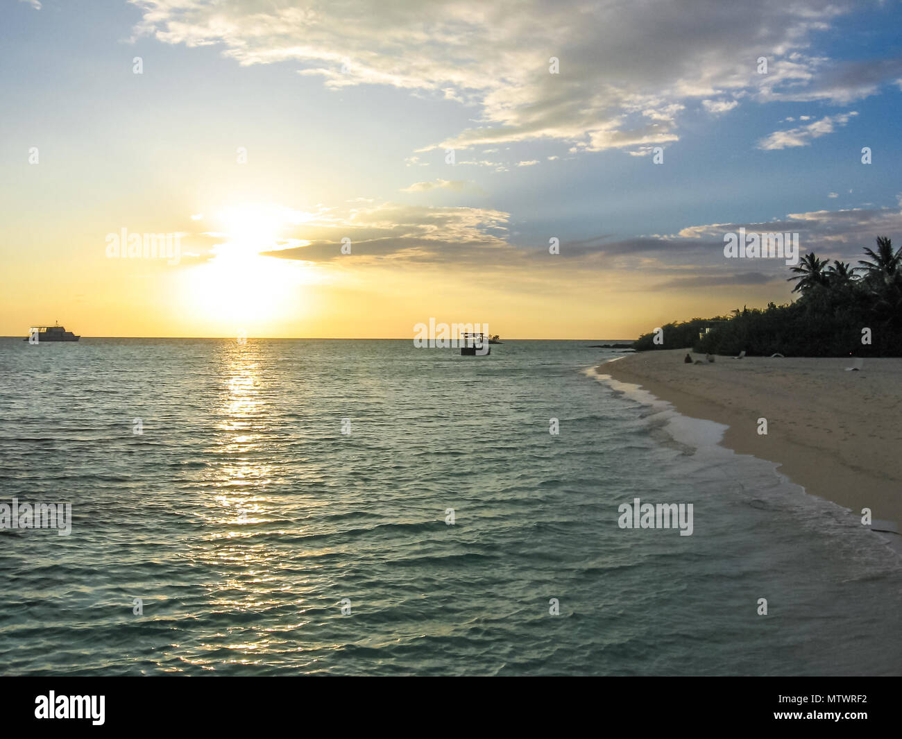 Sunset over the tropical sea and coral beach with colorful clouds in ...