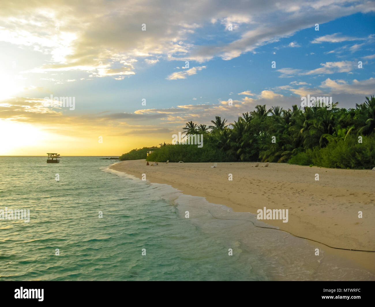 Sunset over the tropical sea and coral beach with colorful clouds in ...