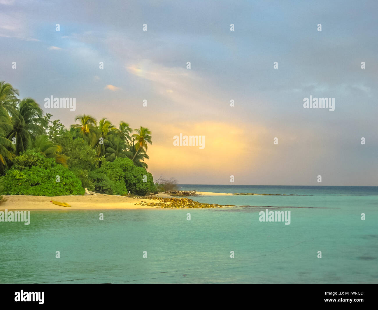Sunset over the tropical sea and coral beach with colorful clouds in ...