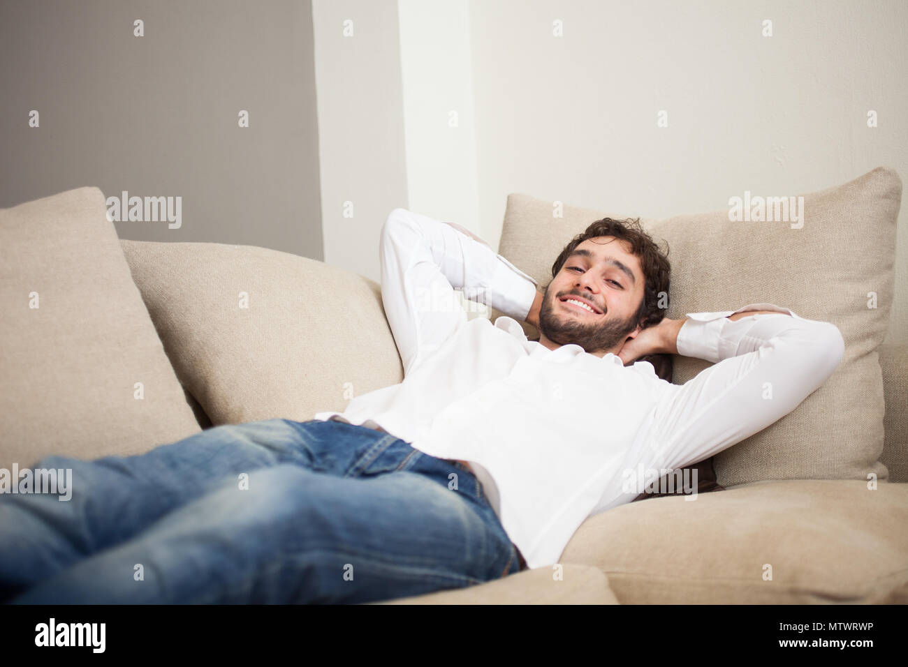 Man relaxing at home on his sofa Stock Photo - Alamy