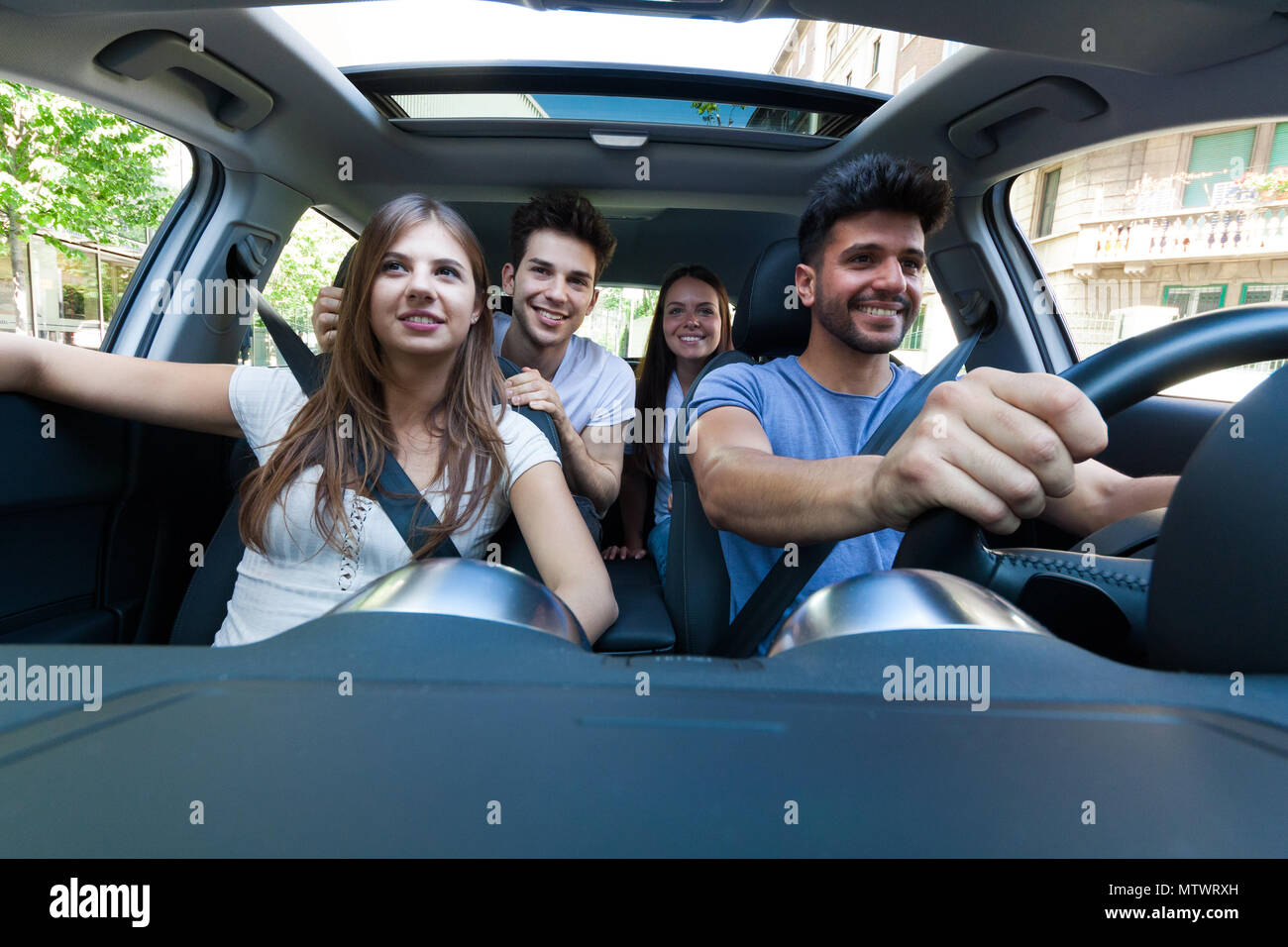 Group of happy friends sharing the same car for a trip Stock Photo - Alamy