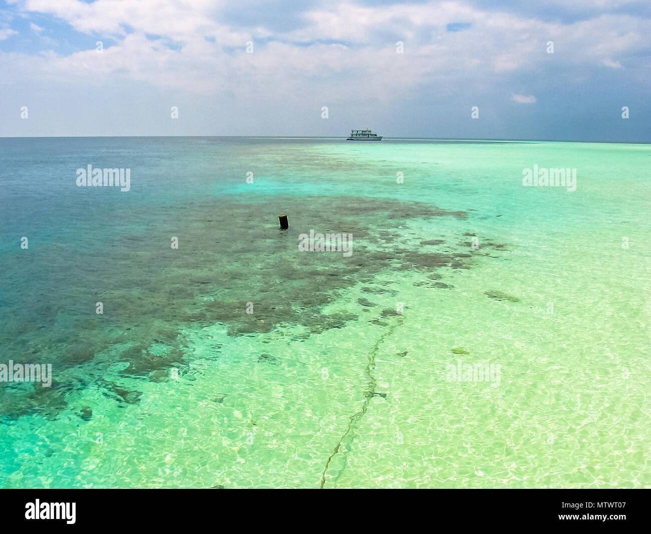 Maldives, Indian Ocean. Turquoise water of the lagoon. Rocks and coral ...