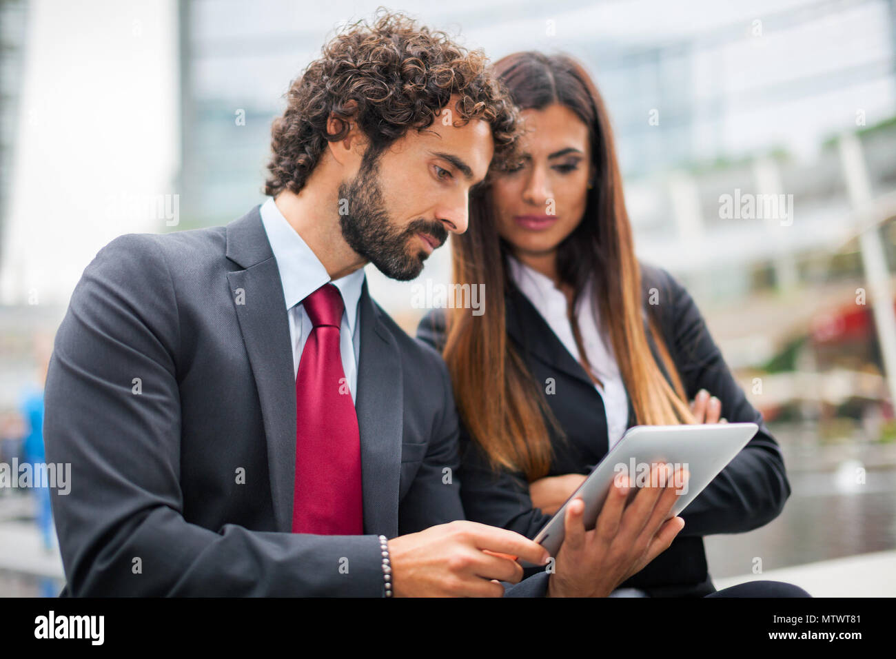 Business people using a tablet together Stock Photo - Alamy