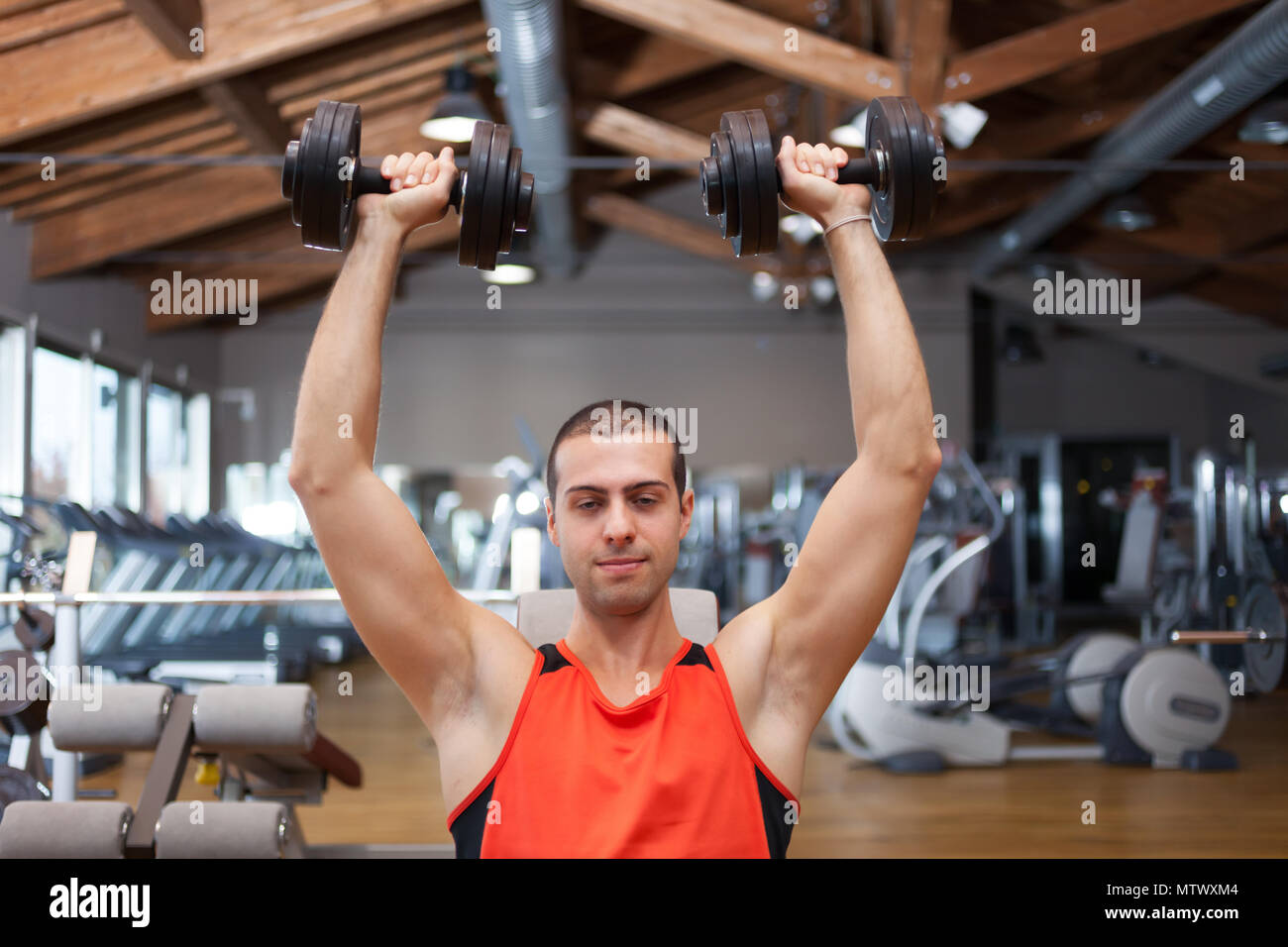 Man lifting a weight in a fitness club Stock Photo - Alamy