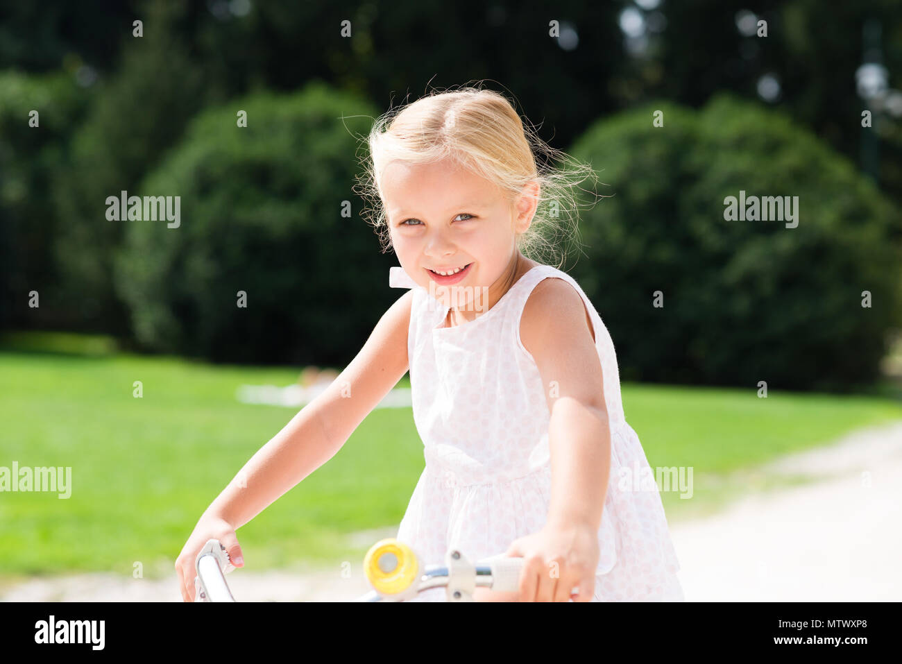 Smiling beautiful child riding on her bike Stock Photo - Alamy