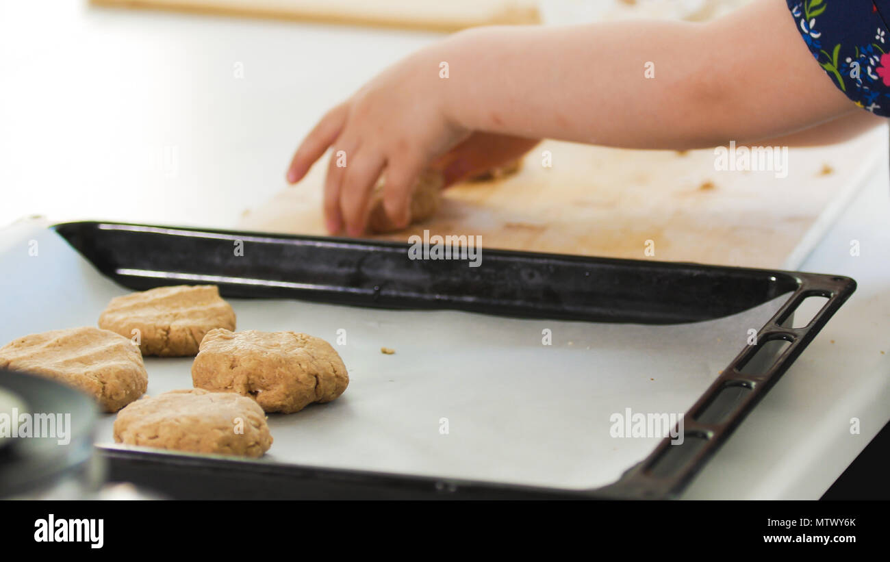 Preschool girl baker puts homemade cookies on a baking sheet Stock ...