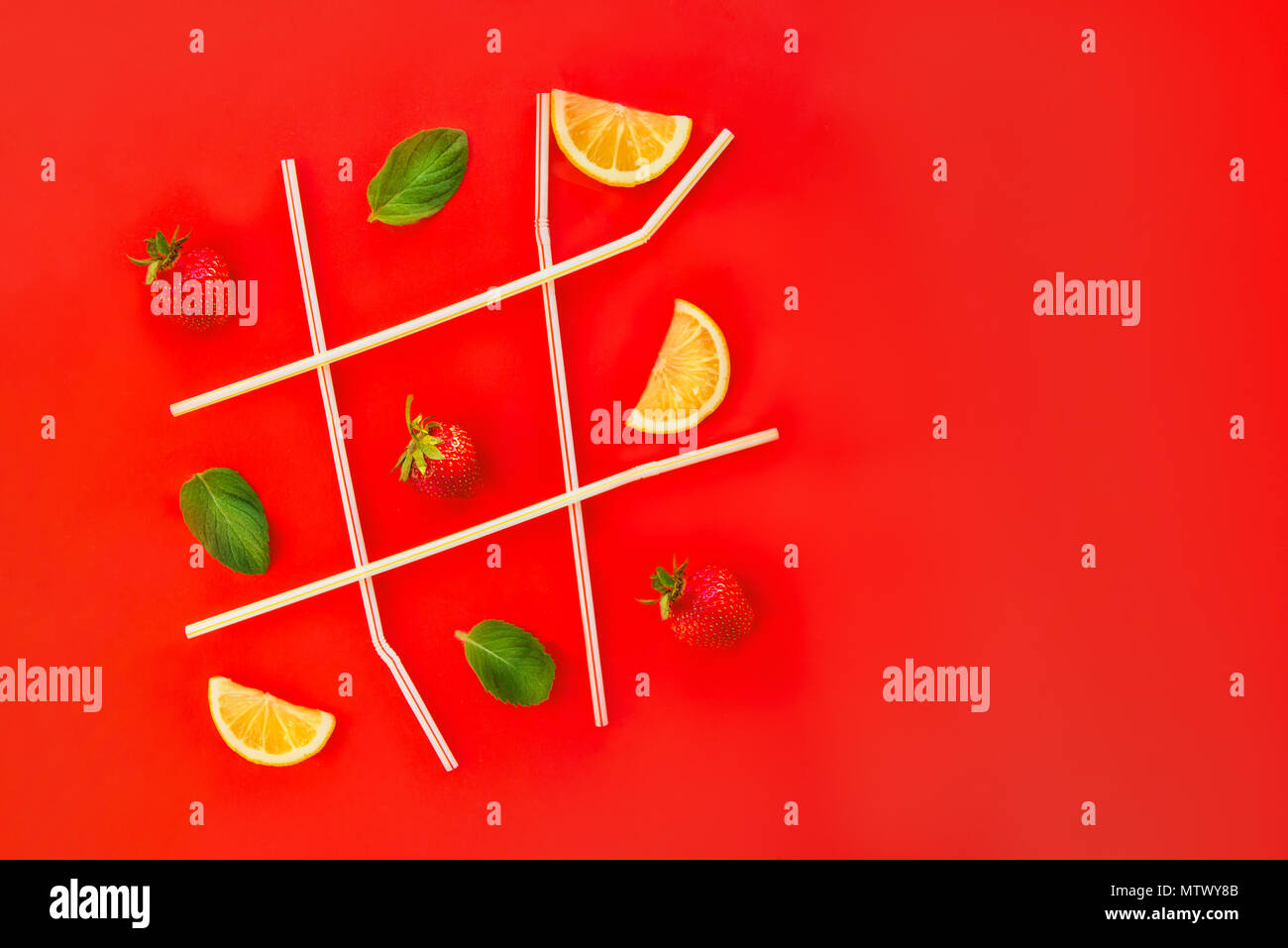Tic tac toe game made of cocktail straws, strawberry, mint and lemon ...