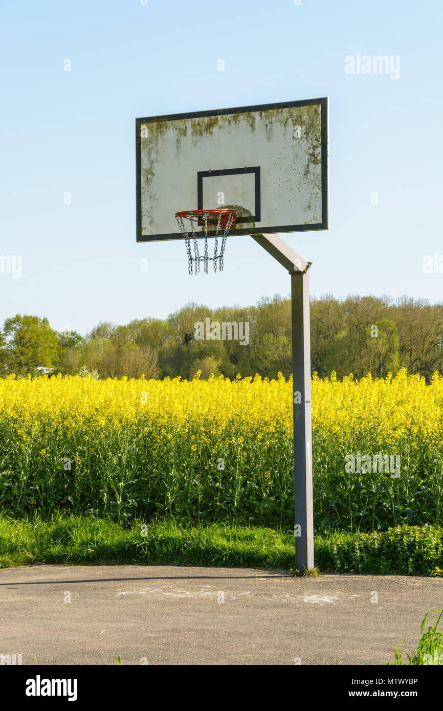 A village basketball court with a single backboard right next to a ...