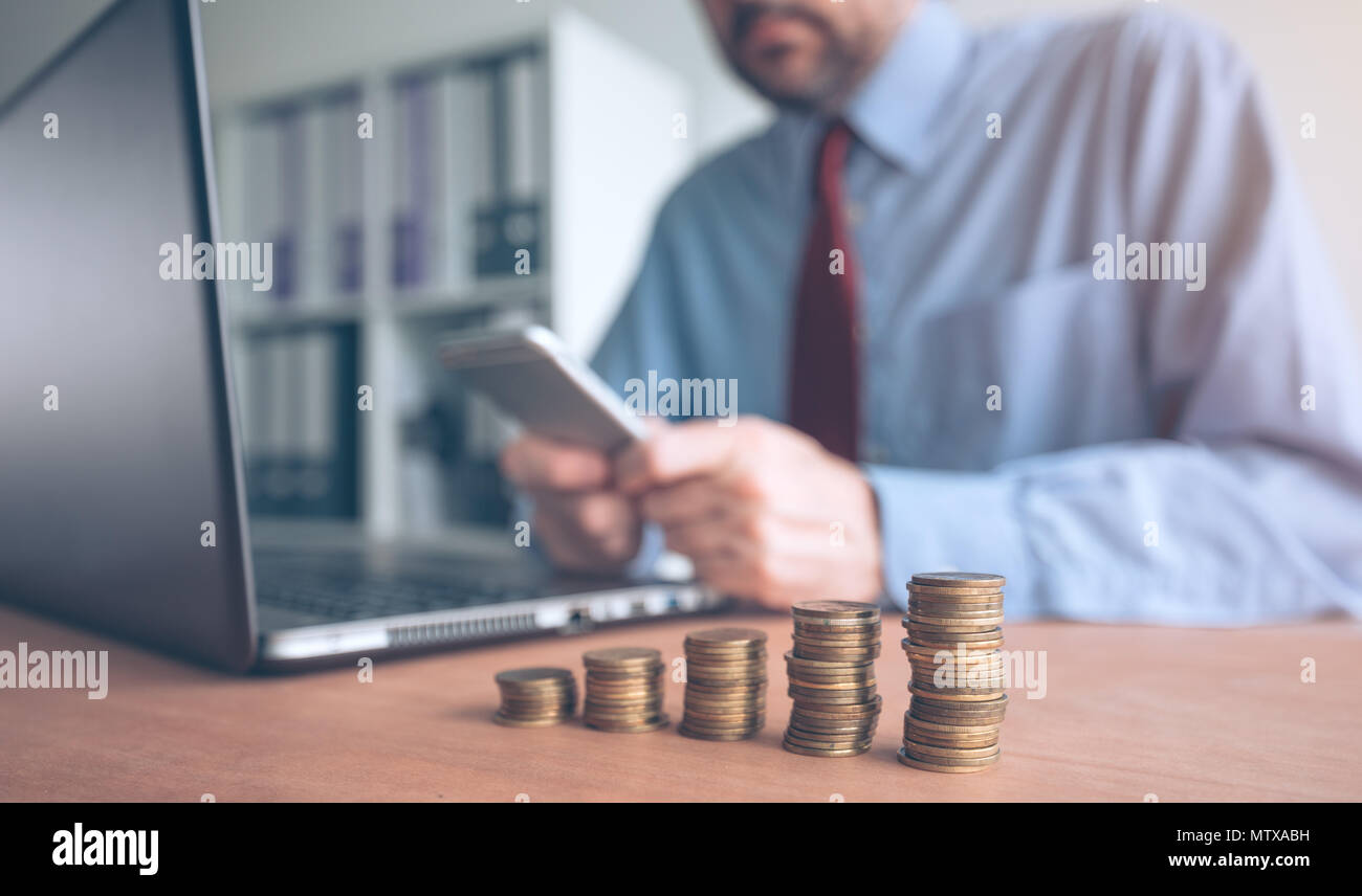 Coin stacker, businessman with stacked money in the office doing ...