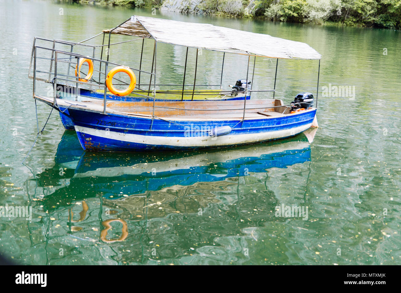 Small boat and reflection on water Stock Photo - Alamy