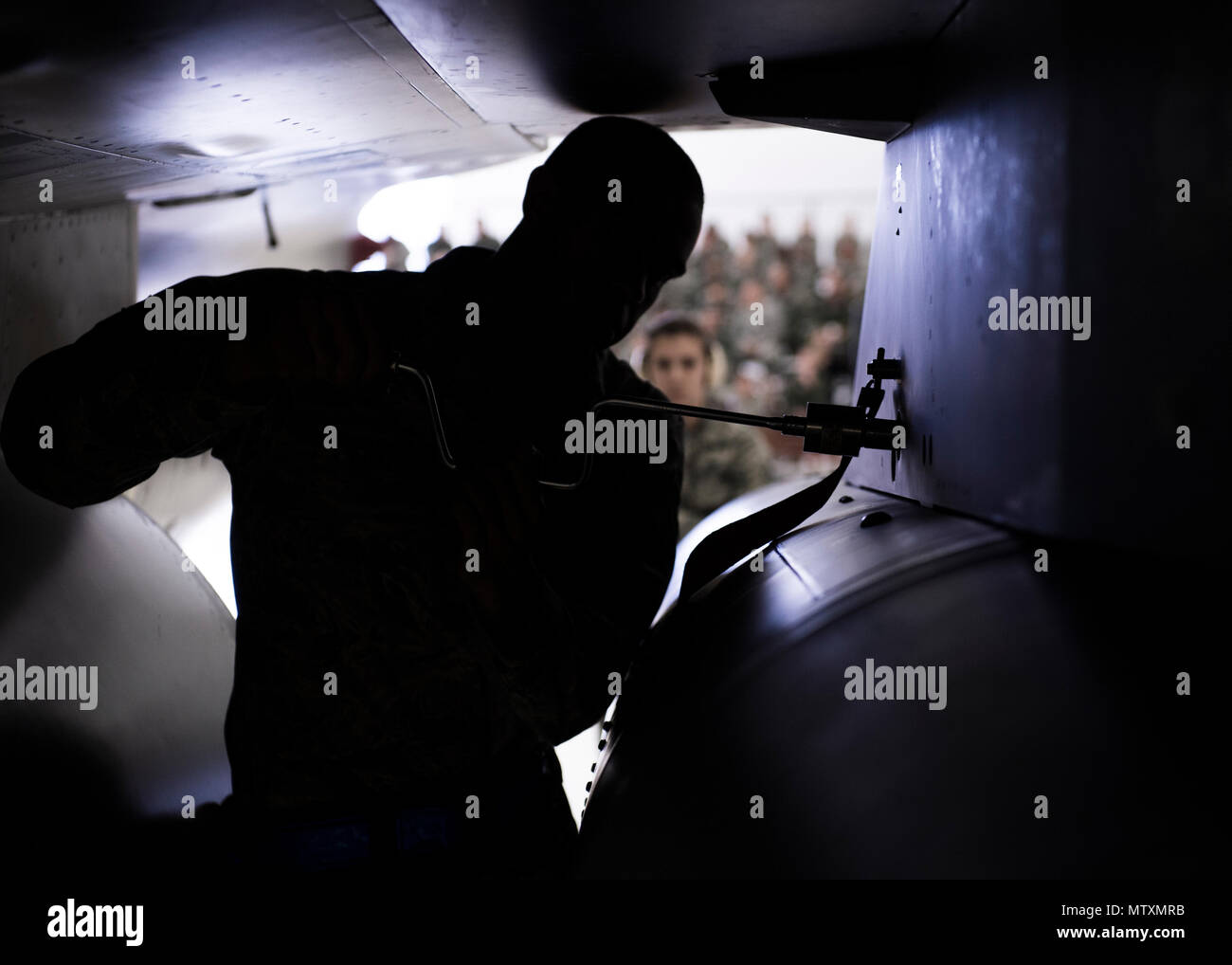 A1C Jonathan, 54th Fighter Group load crew member, secures an inert ...