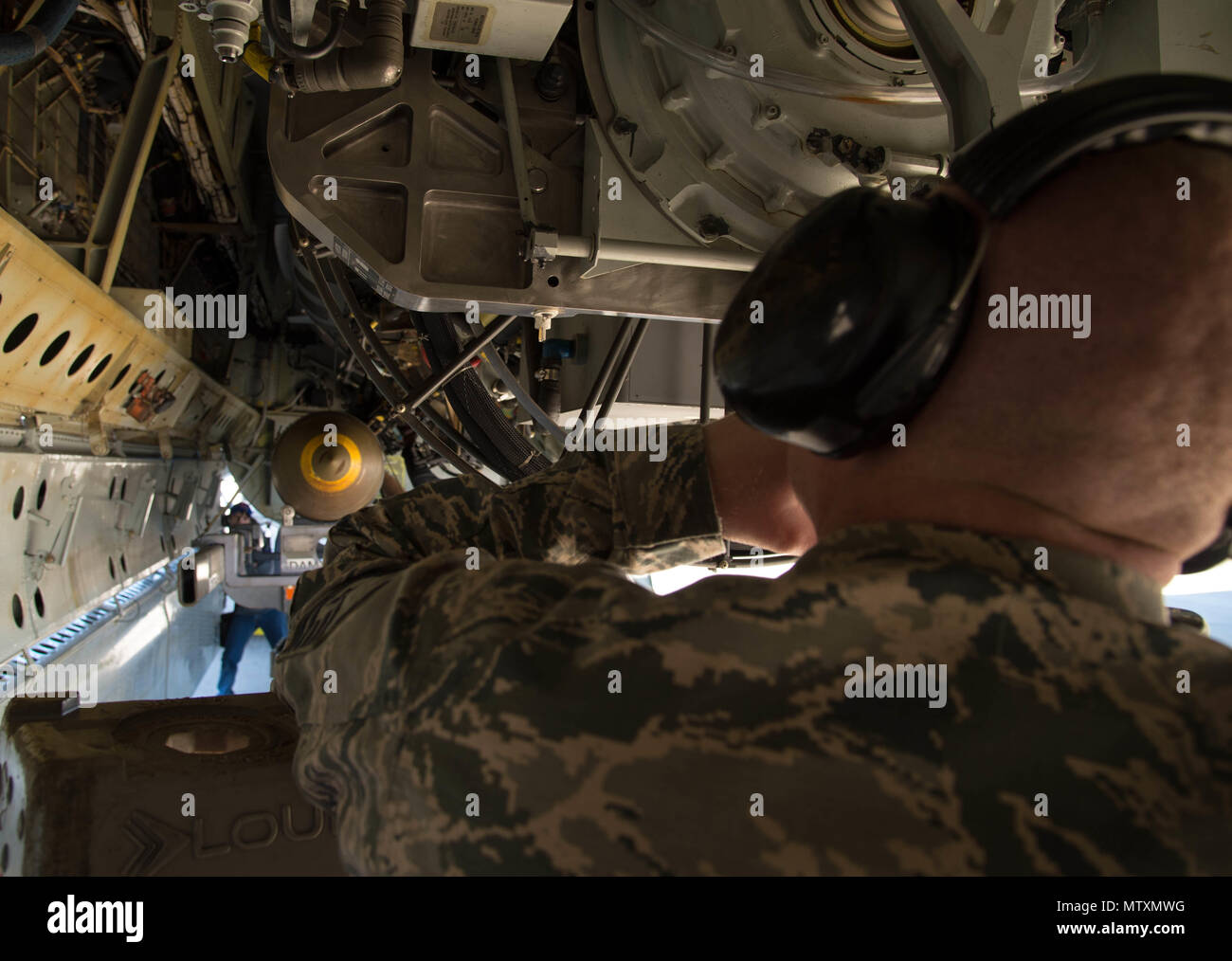 An Airman spots the placement of munitions on a Conventional Rotary ...