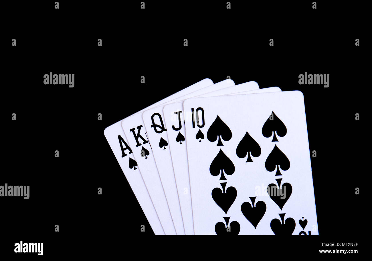 A royal flush in spades isolated against a black background image with ...
