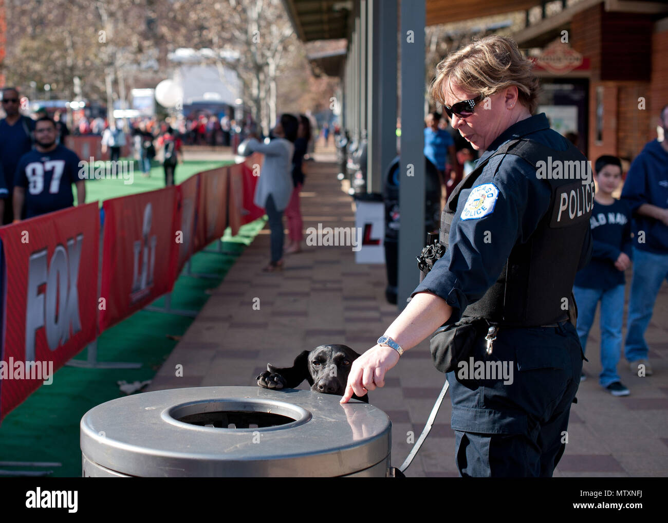 A Chicago Police Officer orders her K-9 to search a trash can at ...