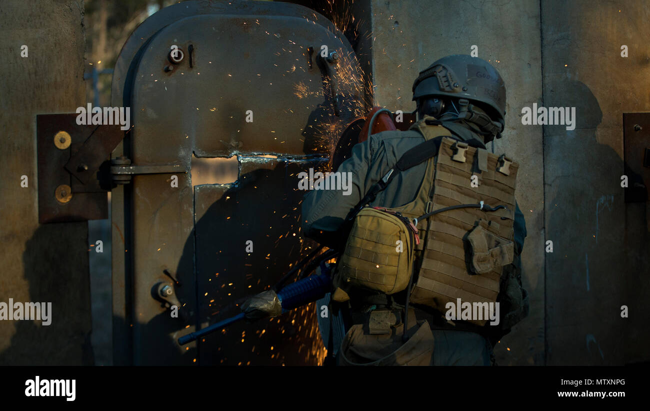 A U.S. Marine attending the Methods of Entry (MOE) course, uses a torch ...