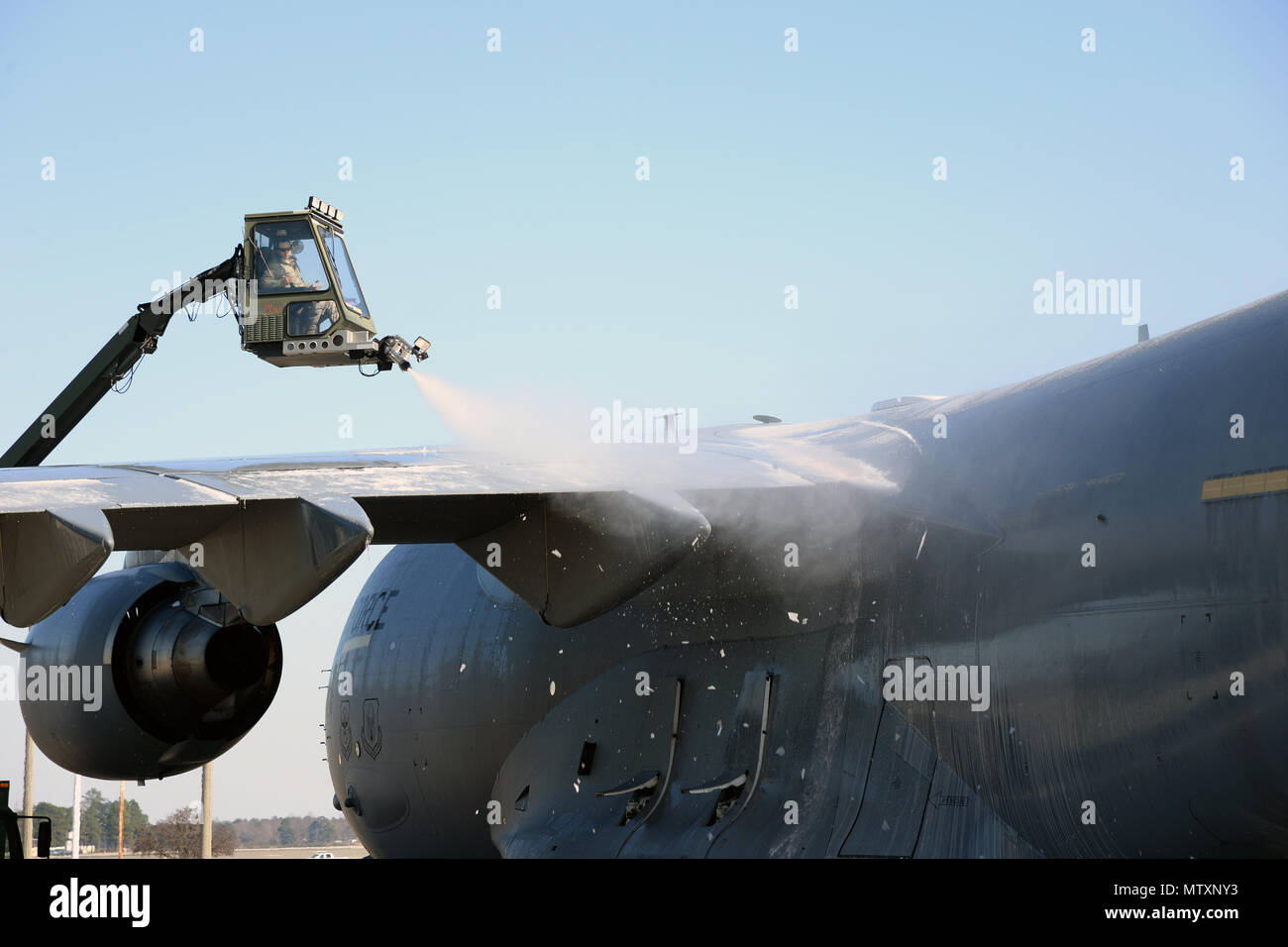 A member of the 43rd Air Mobility Squadron de-ices at C-17 Globemaster ...