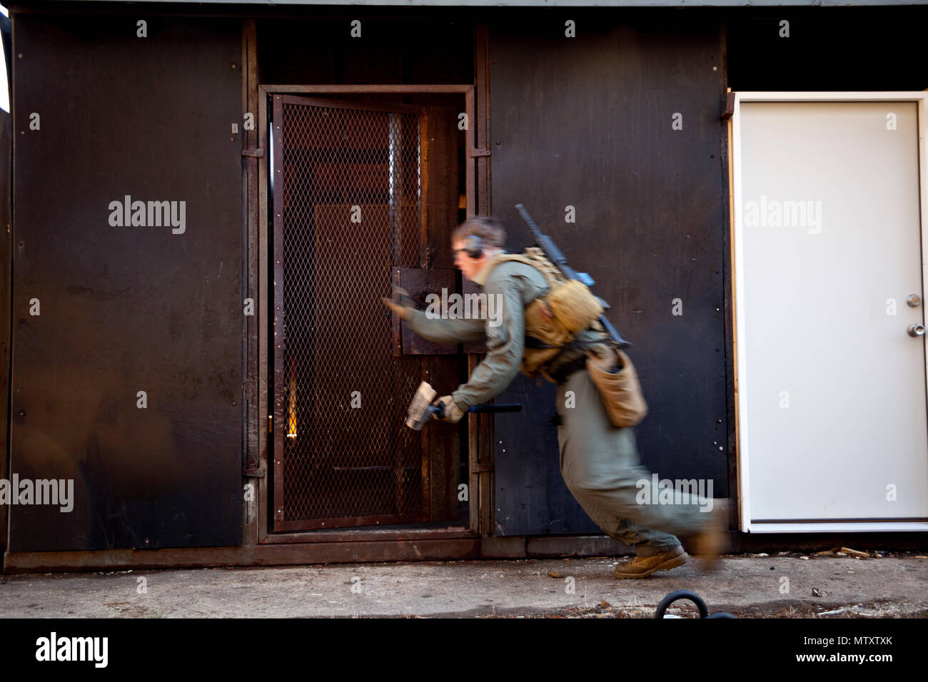 A U.S. Marine attending the Methods of Entry (MOE) course opens a ...