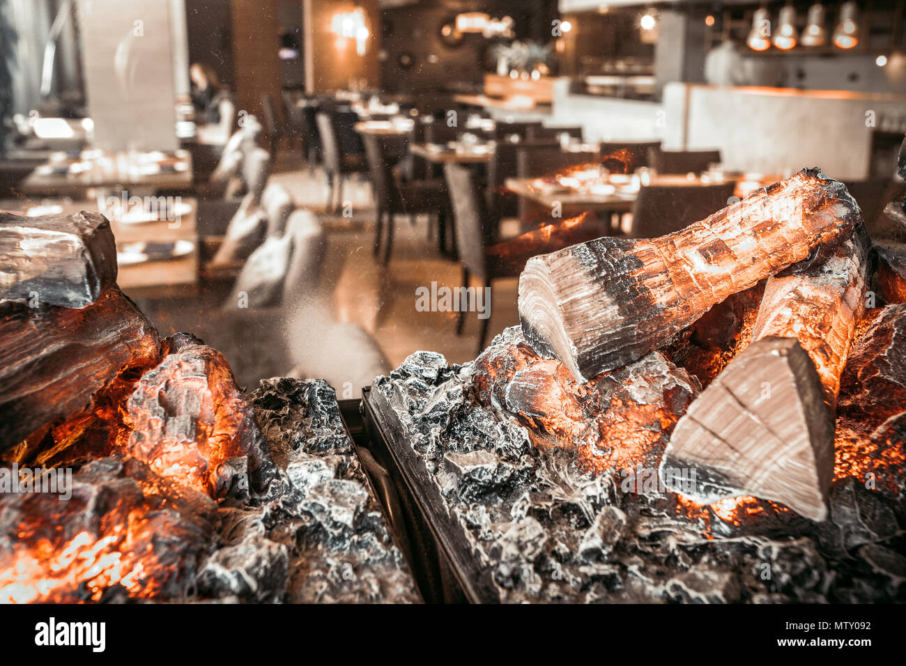 Close-up burning firewood on the stylish main hall interior background ...