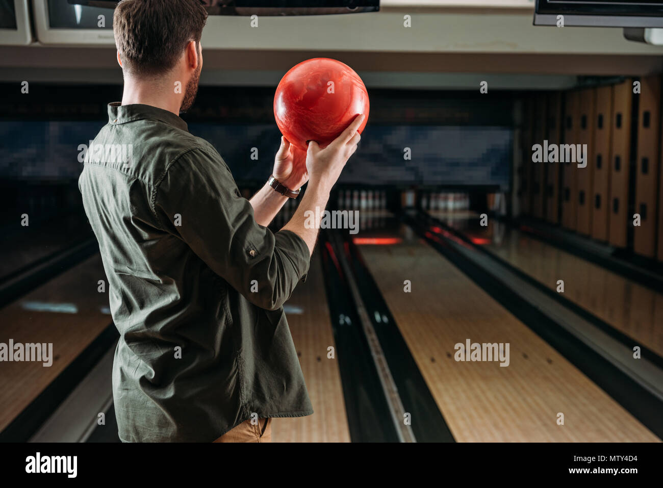 rear view of man with bowling ball looking at alleys Stock Photo - Alamy