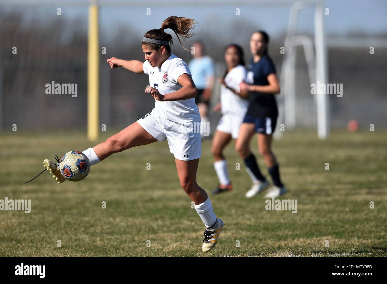 Player extending to keep a ball in play along a sideline and ...