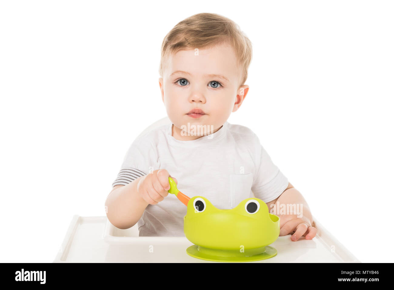 adorable little boy eating from plate in form of frog and sitting in ...