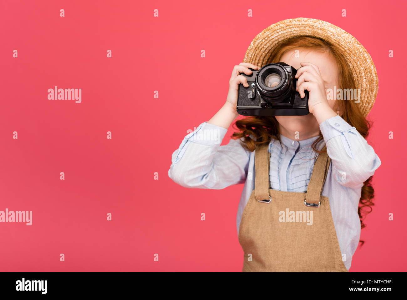 obscured view of child holding photo camera isolated on pink Stock ...