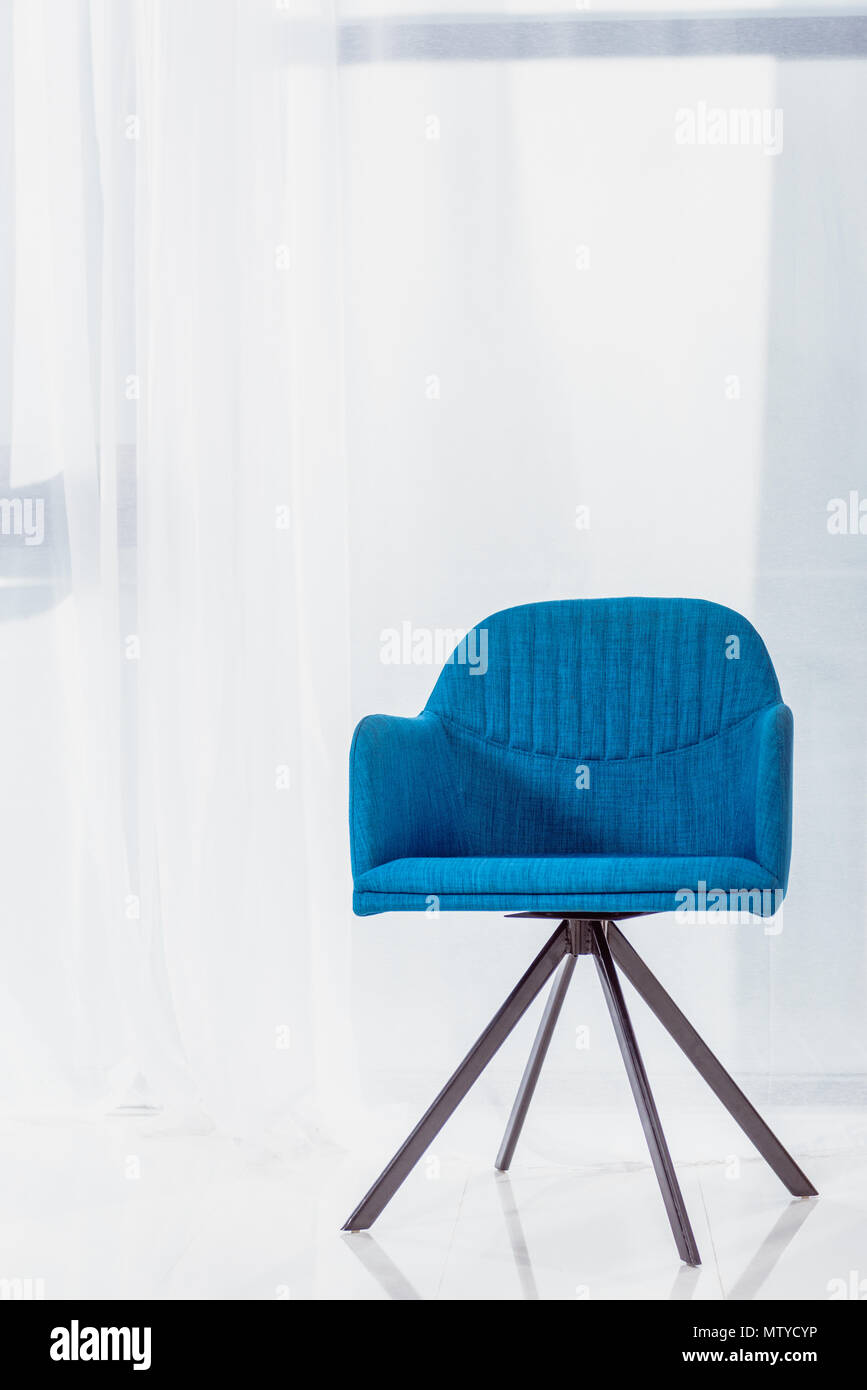 Blue modern chair in room in front of window Stock Photo - Alamy