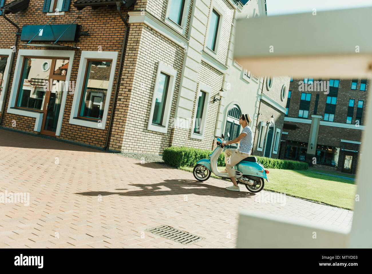 side view of man riding retro scooter on street Stock Photo - Alamy
