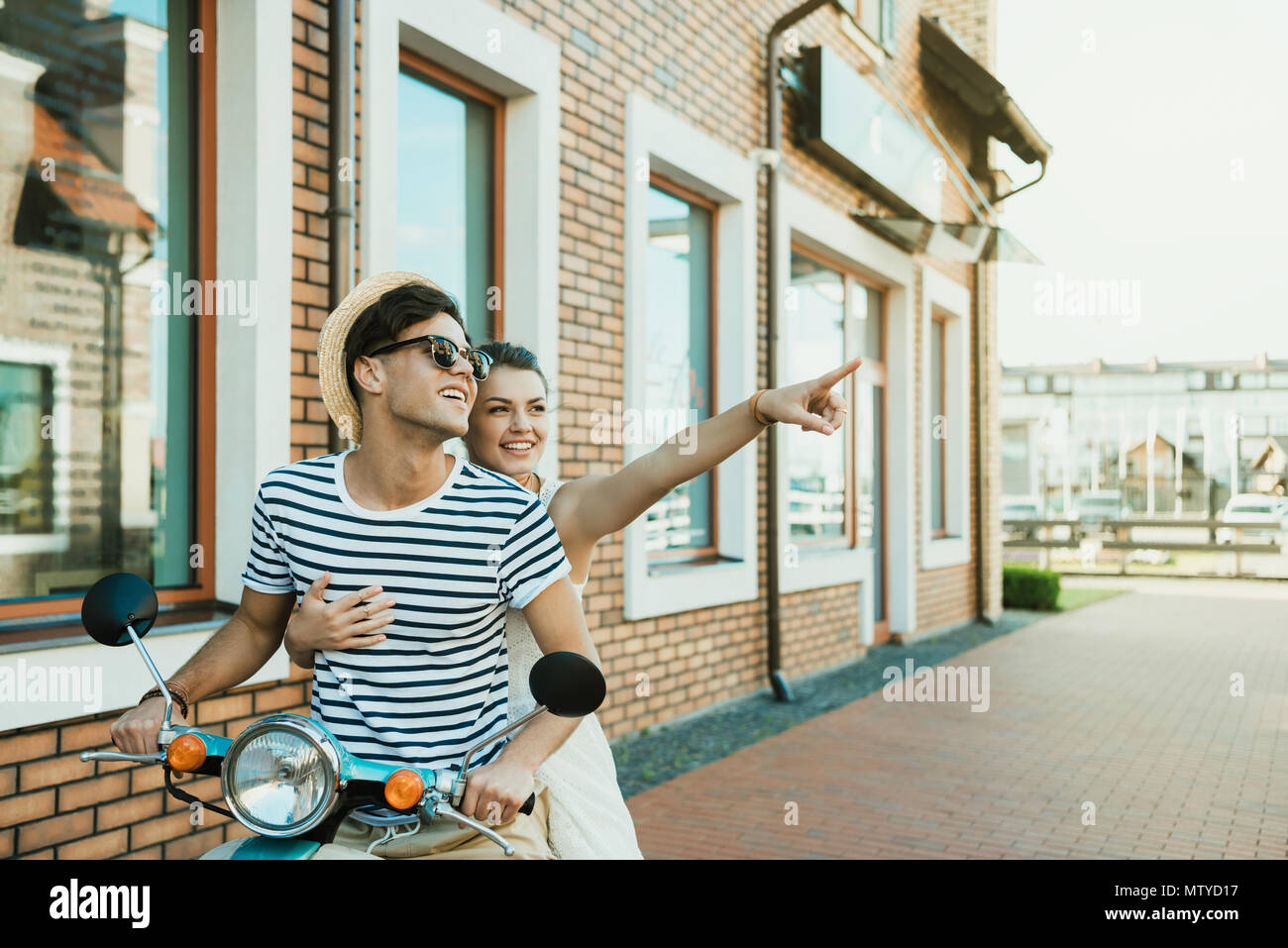 young smiling couple riding on moped together at daytime outdoors Stock ...