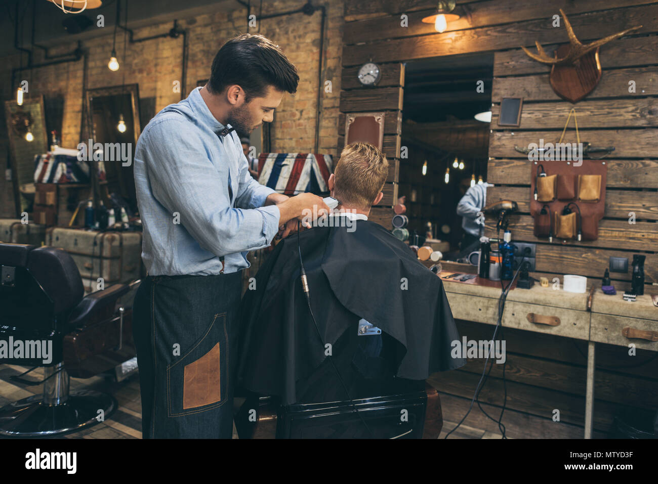 Male barber cutting hair of customer in barber shop Stock Photo - Alamy