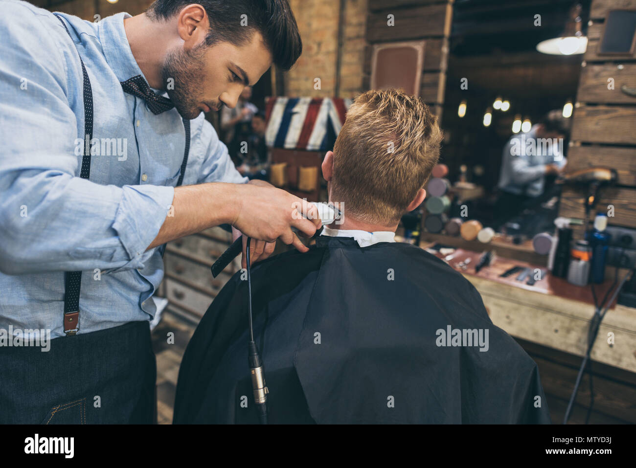 Male barber cutting hair of customer in barber shop Stock Photo - Alamy
