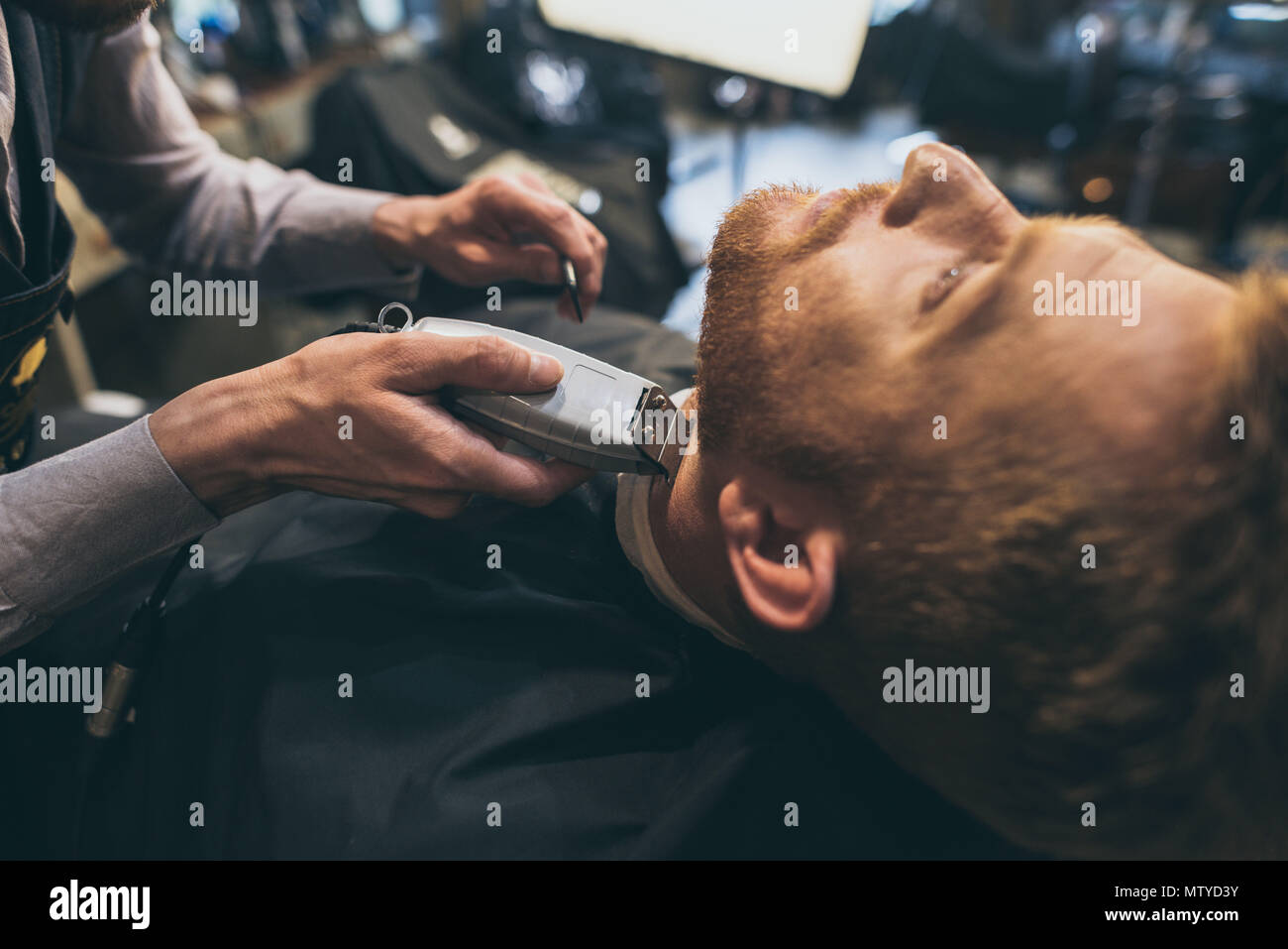 Male barber trimming customers beard in barber shop Stock Photo - Alamy