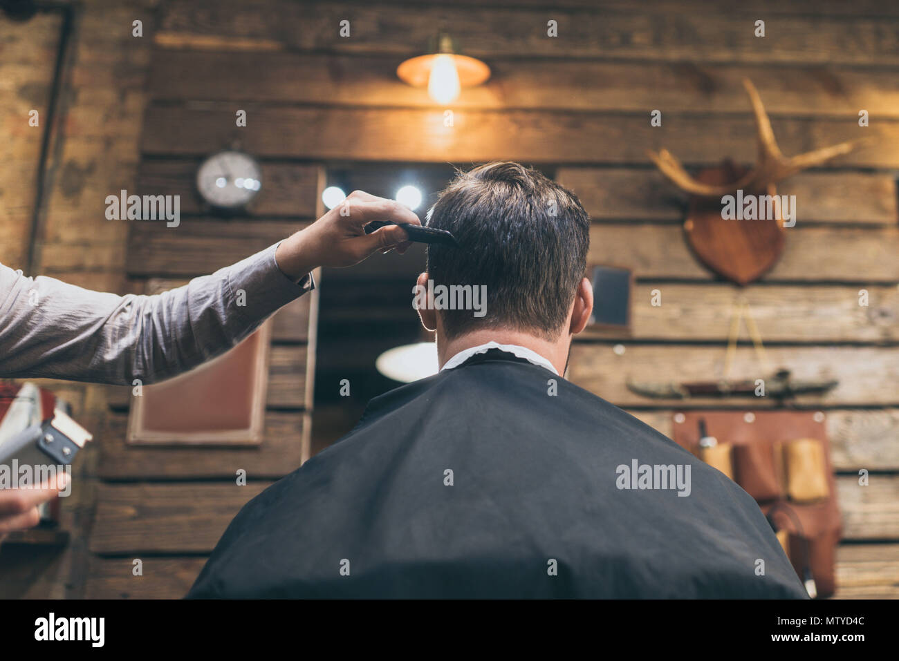 Male barber combing hair of customer in barber shop Stock Photo - Alamy