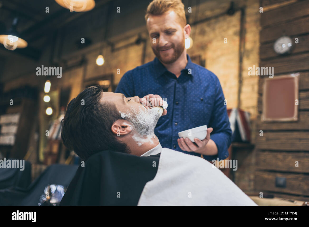 Barber applying foam before shaving of customer in barber shop Stock ...