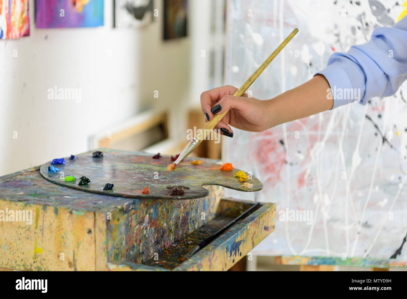cropped image of artist taking paint from palette in workshop Stock ...