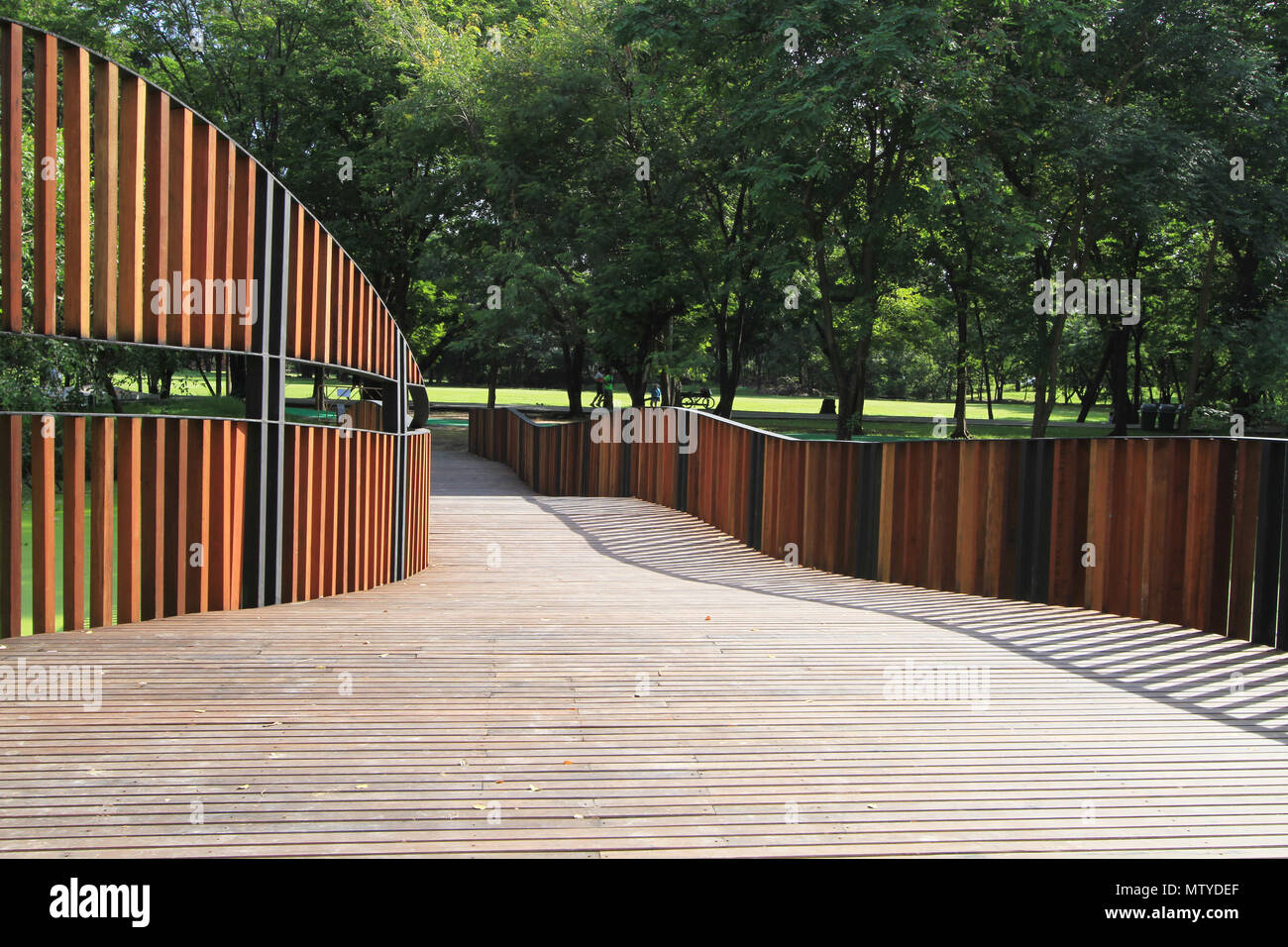 Wooden walkway with handrail in the park Stock Photo - Alamy