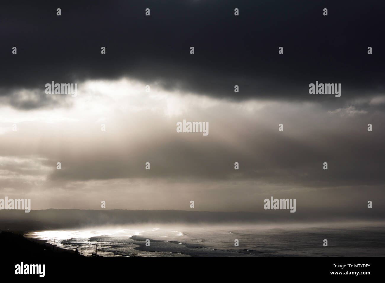 Gray Coastal Sky With Sunlight Shimmering On Ocean Below Stock Photo ...