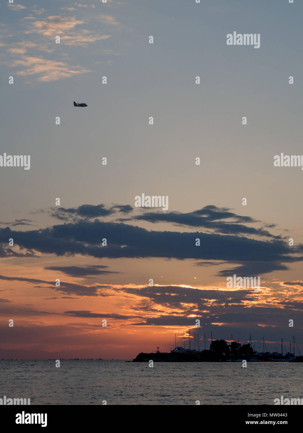 Airplane flying in dramatic sunset sky hi-res stock photography and ...
