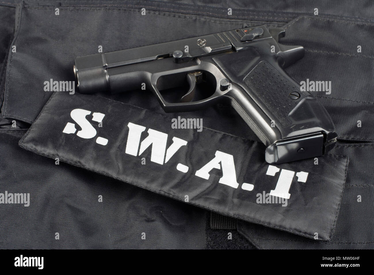SWAT teams concept -handgun on black uniform background Stock Photo - Alamy
